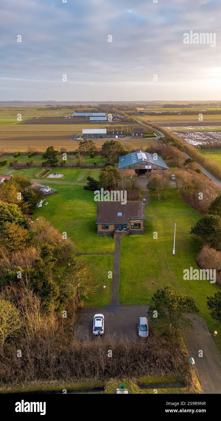 A scenic aerial view of a countryside house surrounded by lush green ...