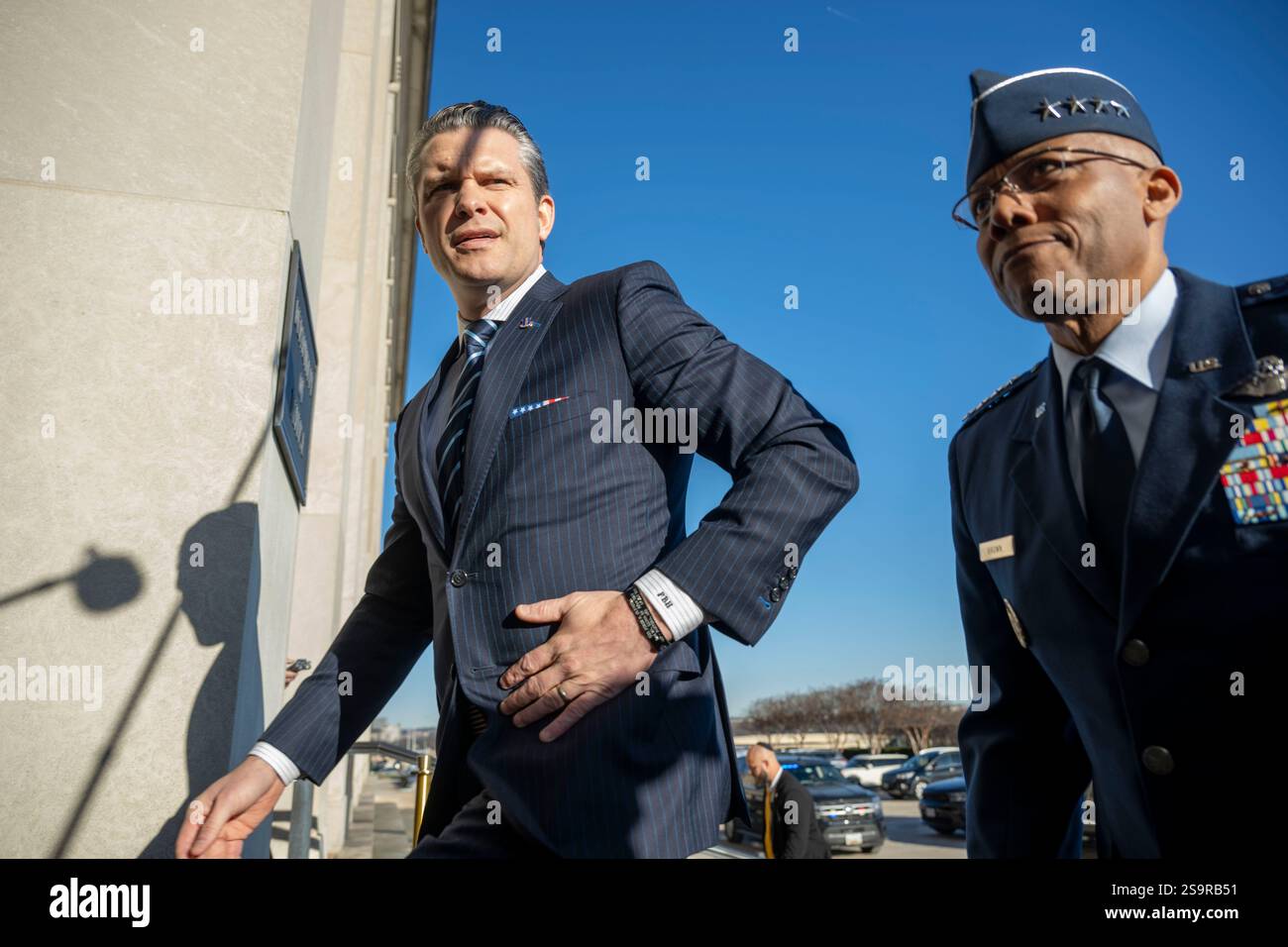 Defense Secretary Pete Hegseth walks into the Pentagon with Chairman of the Joint Chiefs of ...