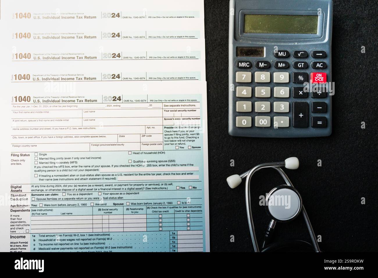 Federal income tax return preparation with 1040 form and calculator for ...