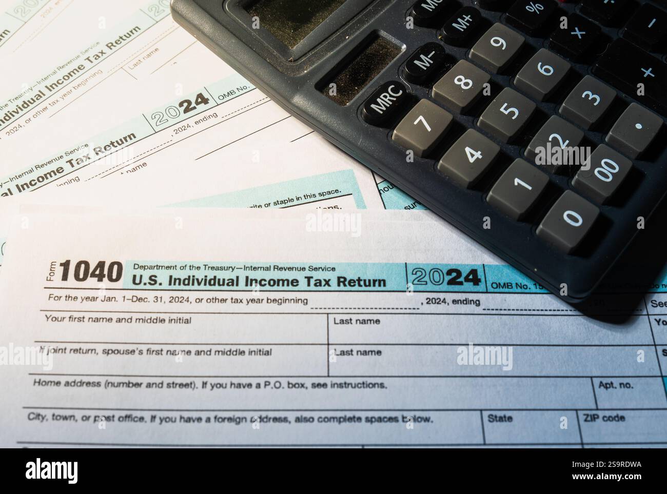 Federal income tax return preparation with 1040 form and calculator for ...