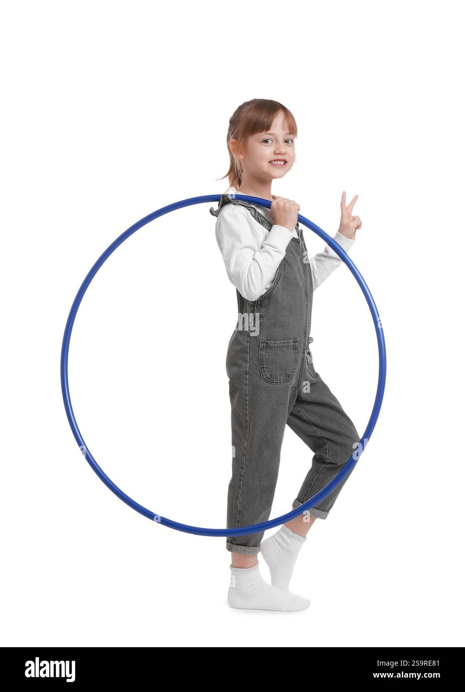 Cute little girl with hula hoop showing V-sign on white background ...