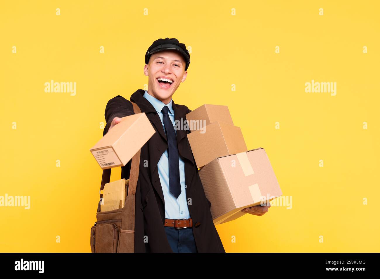 Happy postman with bag giving parcel on yellow background Stock Photo ...