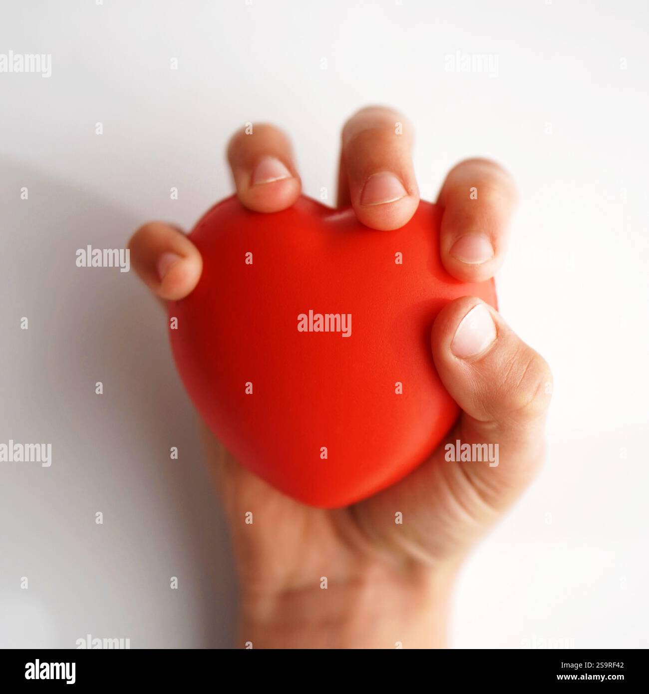 hand squeezing a heart in a tightly clenched fist. stress concept Stock ...