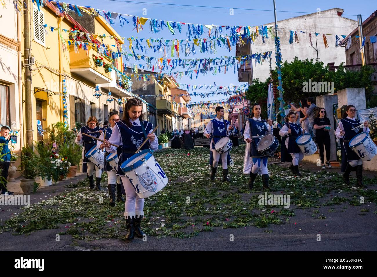 A group of traditionally dressed people walk through the streets in ...