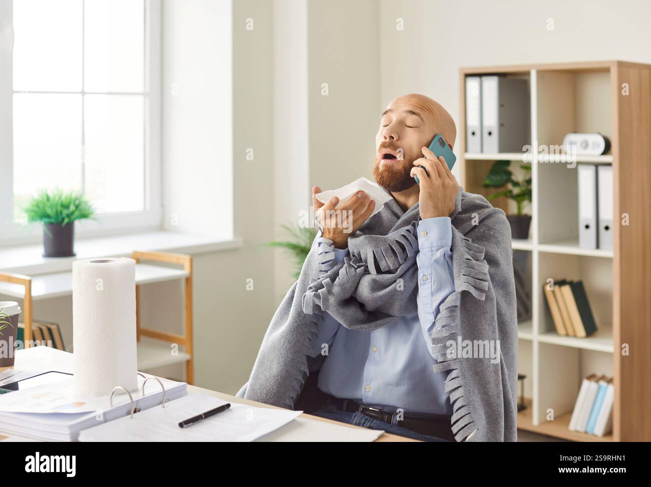 Sick office employee sneezing man wrapped in warm blanket phone call ...