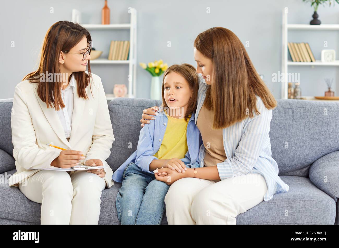 Psychologist talking with upset child girl sitting with her mother on ...