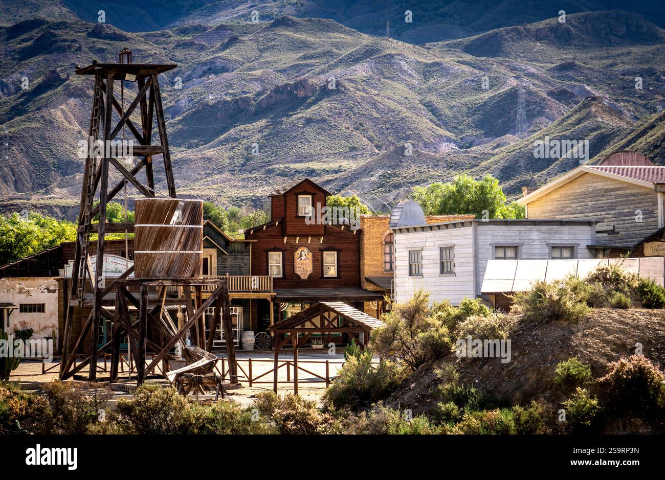 A scenic view of an old western town with wooden buildings, a water ...
