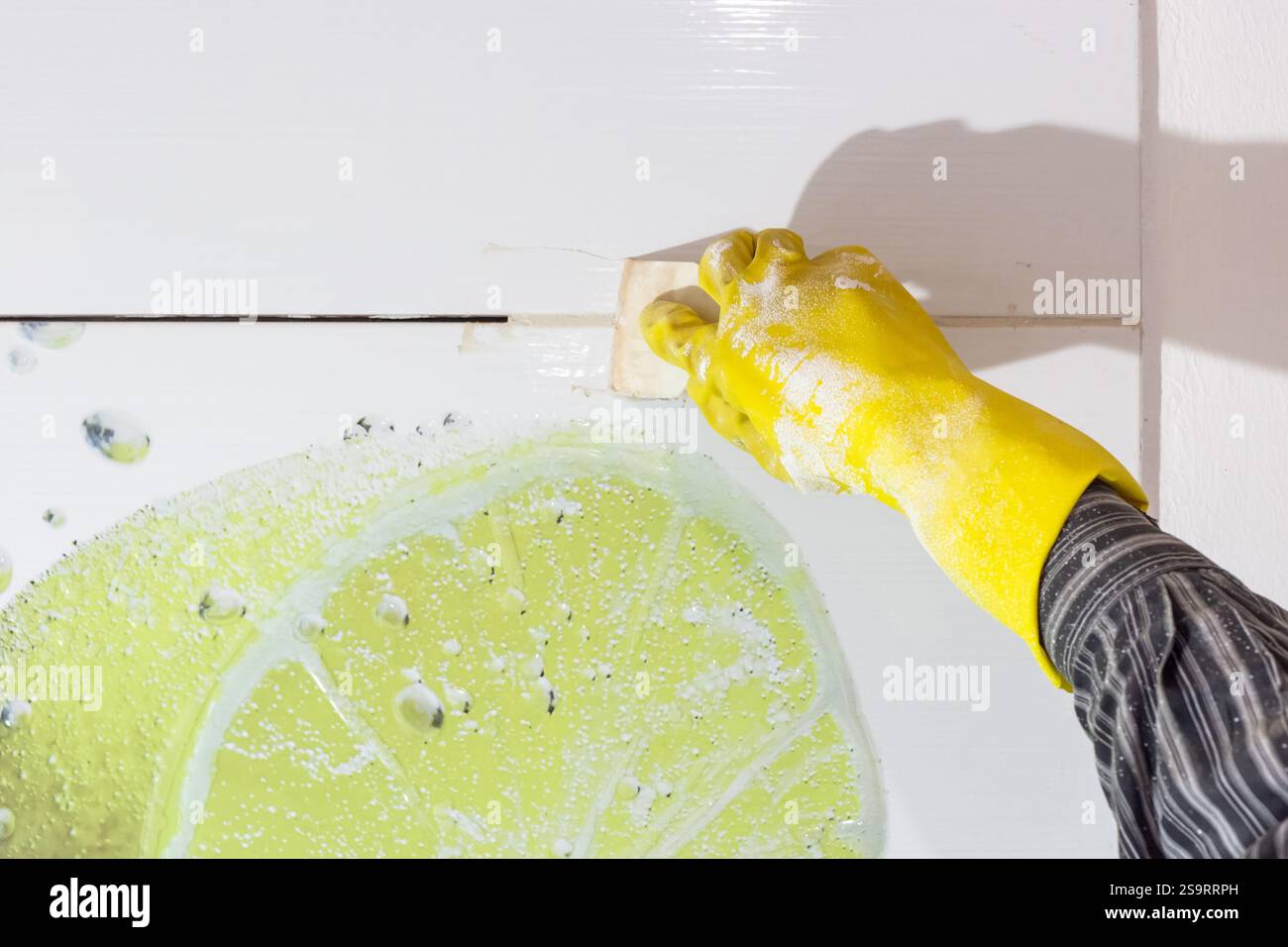 Laying ceramic tiles. The craftsman fills the tile joints with grout ...