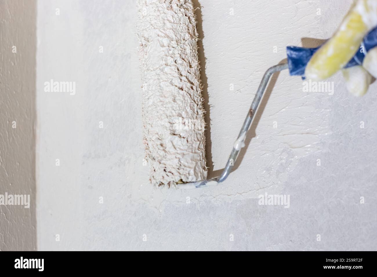 Home renovation. The craftsman plasters drywall walls with a roller ...