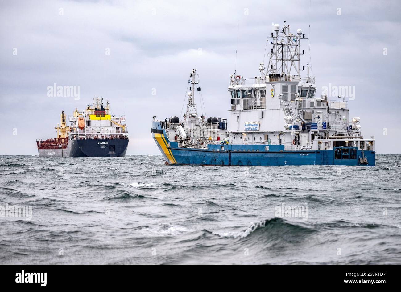 The Swedish Coast Guard vessel KBV033, right, guards next to the cargo ...