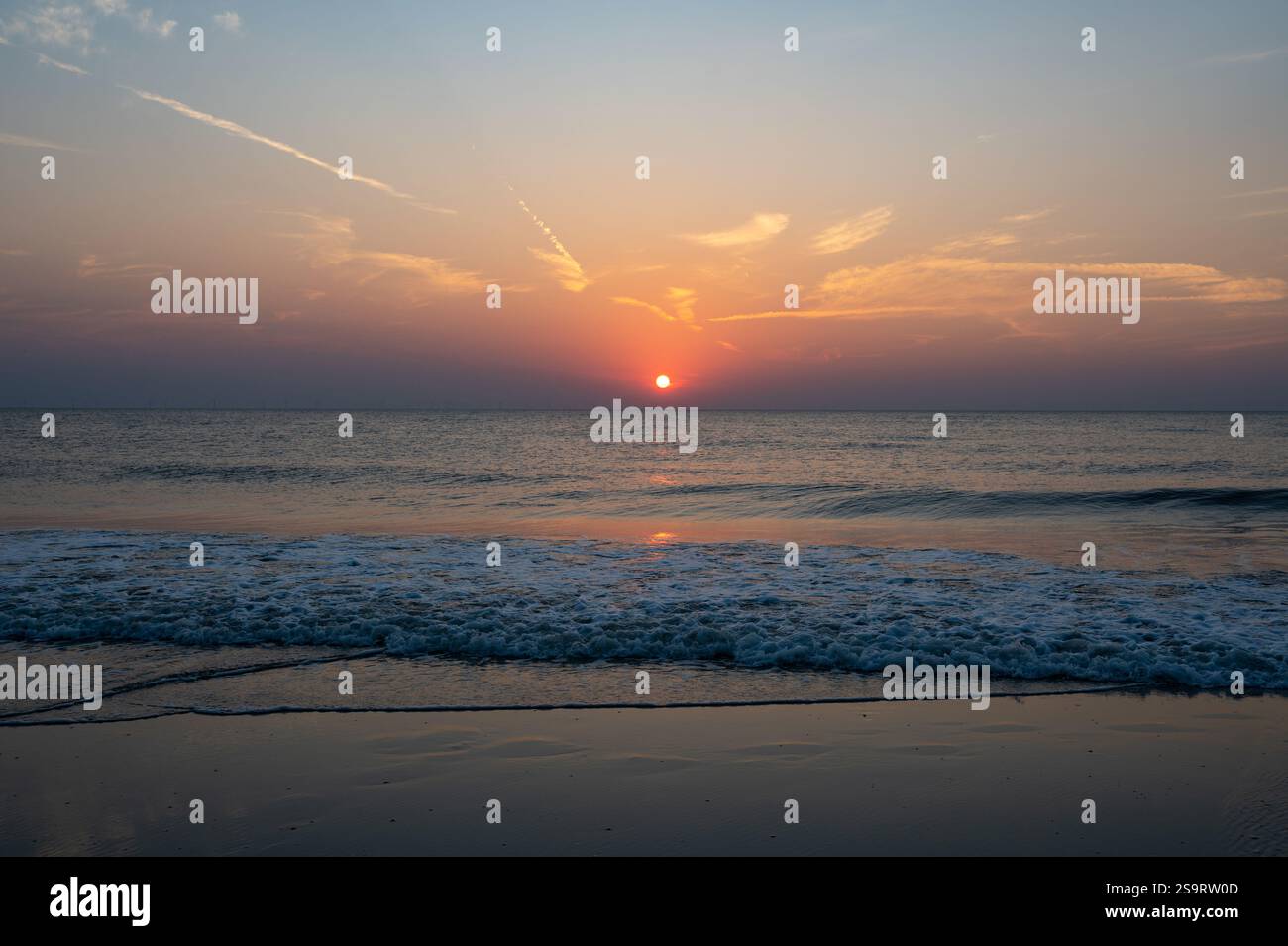 Sunset with red sun over the sea, with waves and sandy beach Stock ...
