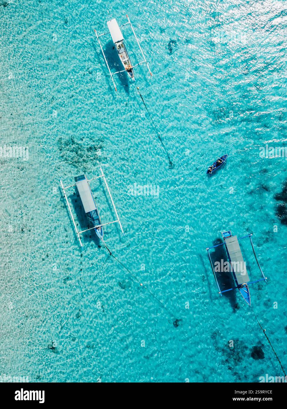 Boats are at anchor in transparent blue ocean on Bali island. Aerial ...