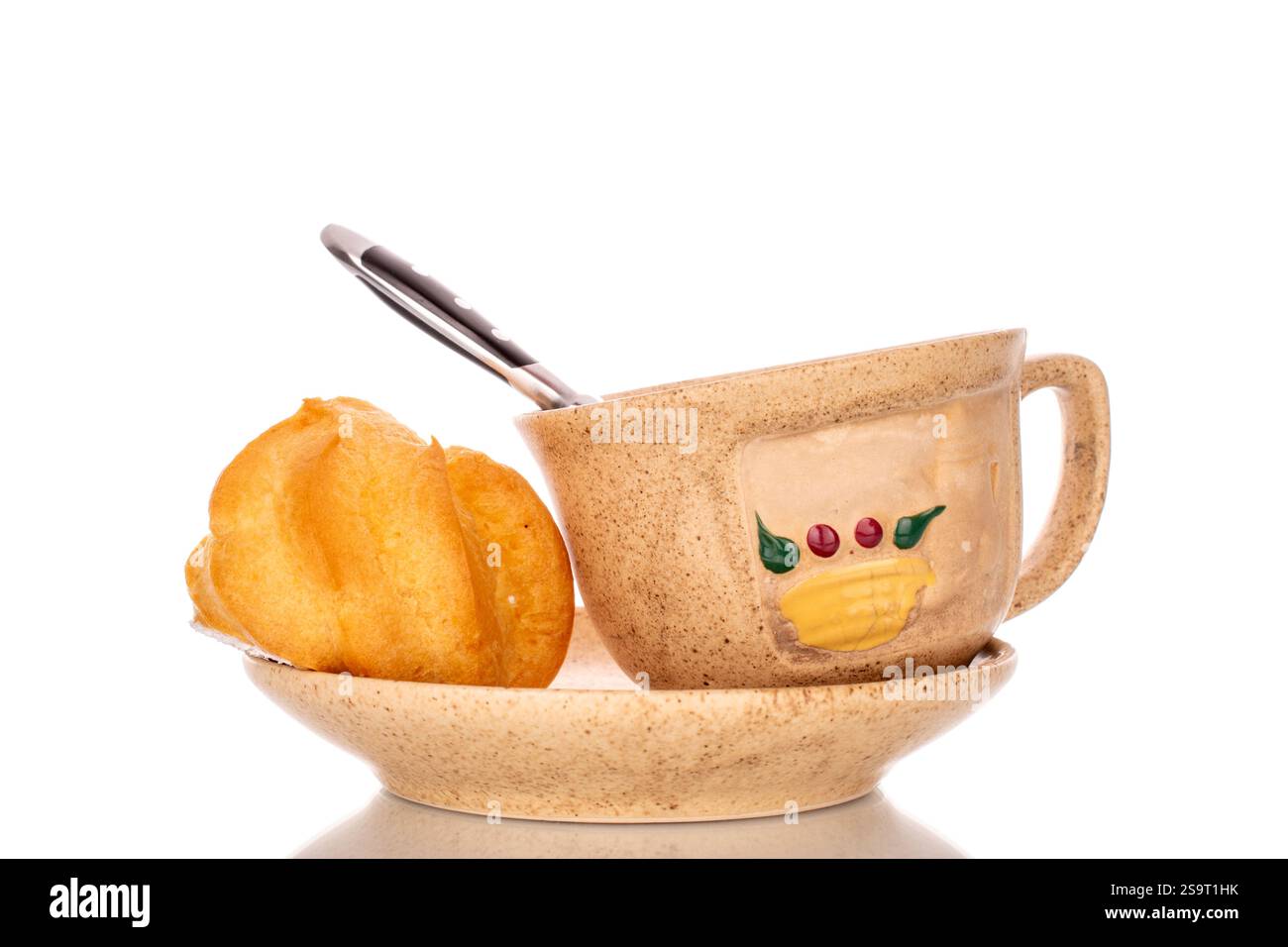 One eclair with ceramic cup on saucer, close-up, isolated on white ...