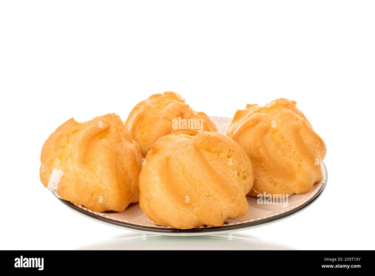Four eclairs on a ceramic saucer on a white background, close-up Stock ...