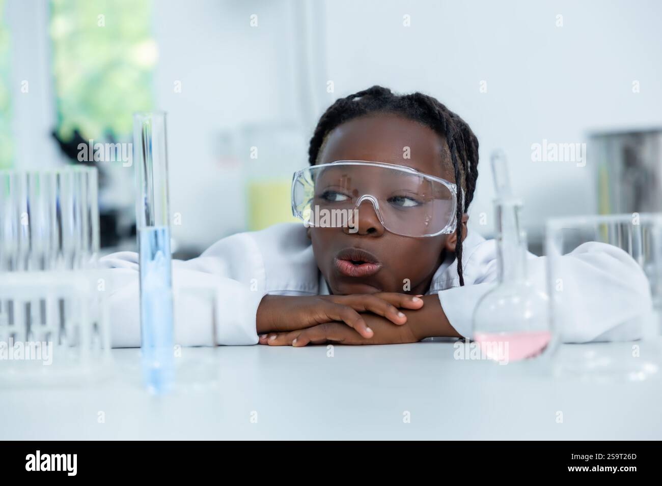 Female chemist in lab testing liquid in flask and tube conducting ...