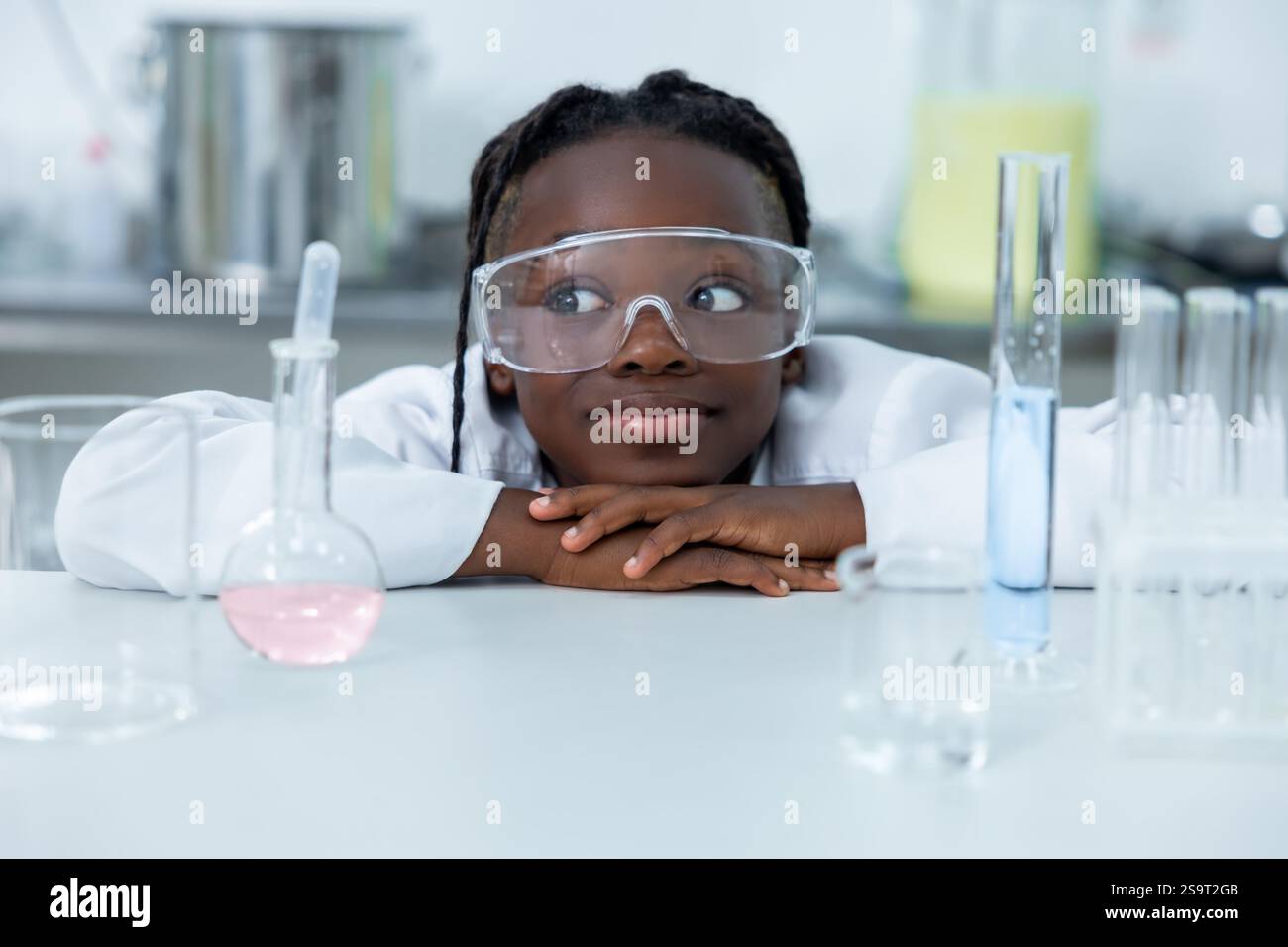 Female chemist in lab testing liquid in flask and tube conducting ...
