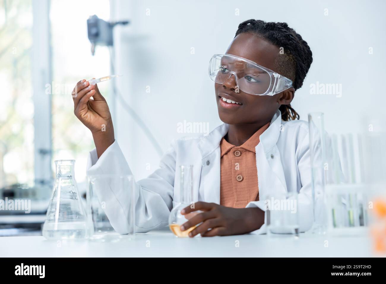 African American scientist in lab using pipette testing bacteria sample ...