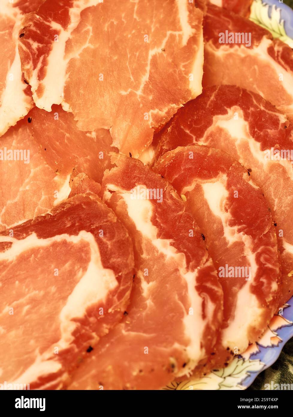 Deliciously sliced cured meat arranged artfully on a decorative plate ...