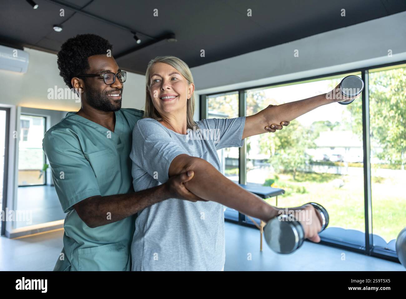Man physiotherapist exercising with patient in therapy session for ...