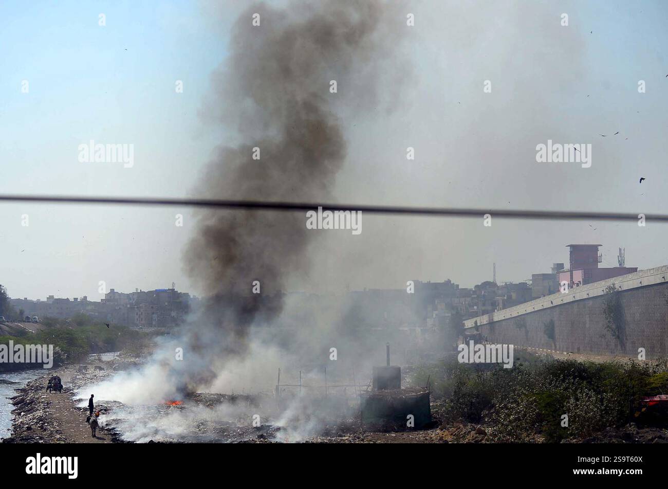 Fire flame rises from burning heap of garbage and bushes after fire ...