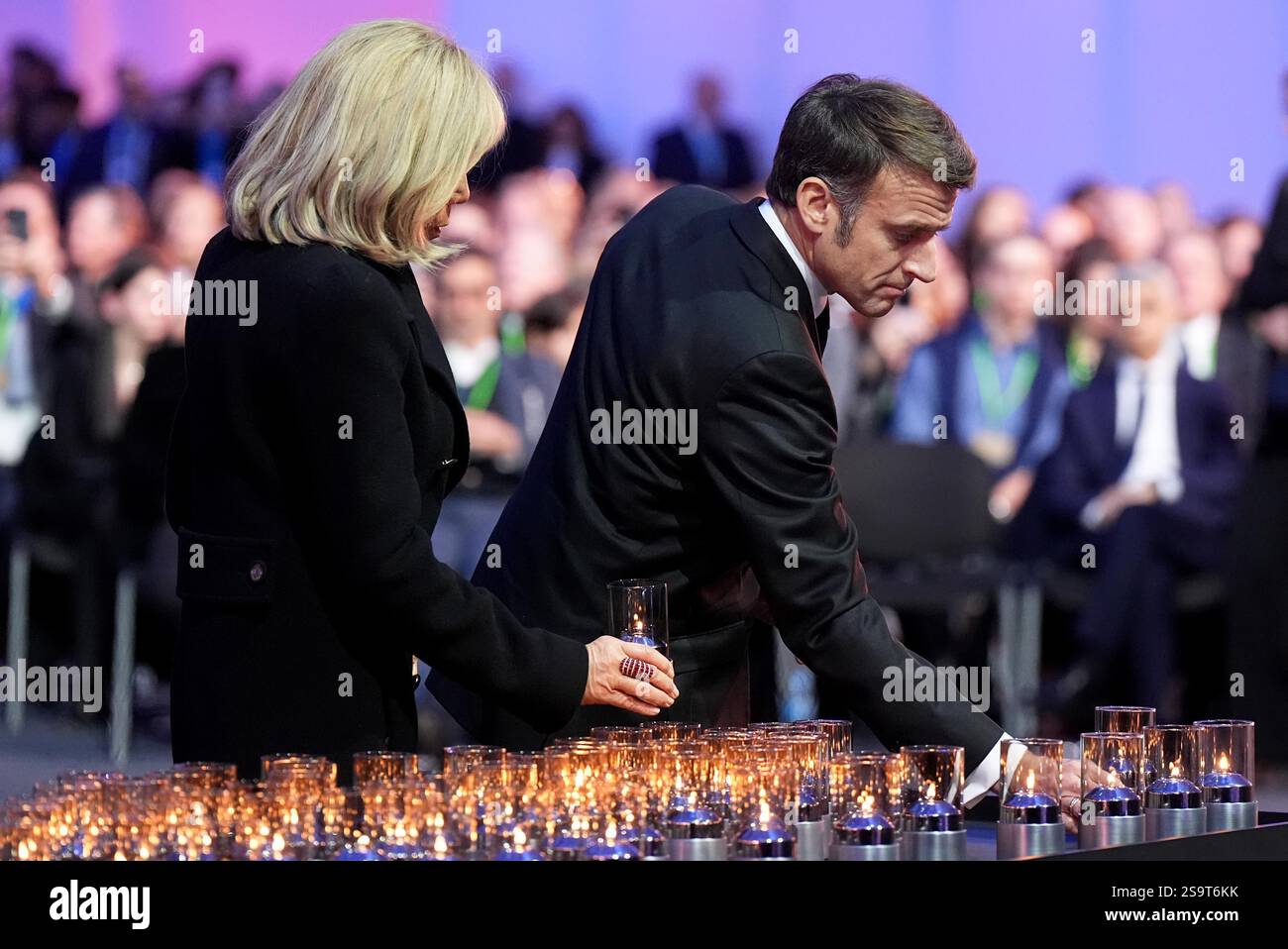 French President Emmanuel Macron (right) lays a candle during ...