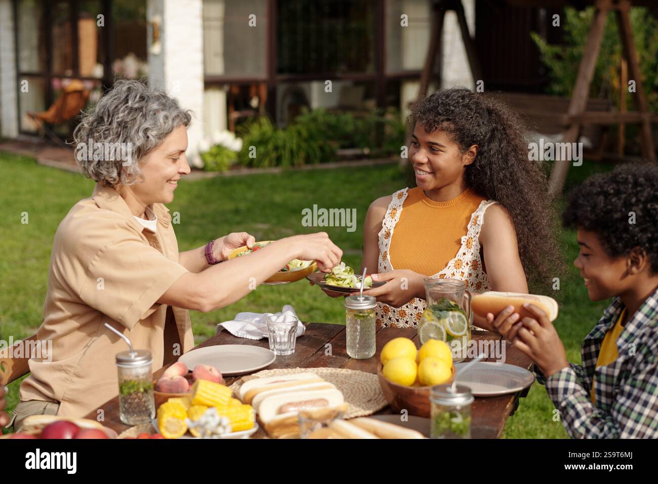 Sharing Family Meal Outdoors with Smiling Relatives Stock Photo - Alamy