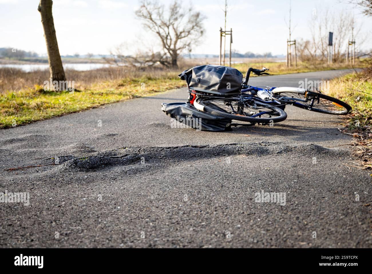 Cycle path with damaged asphalt and fallen bicycle Stock Photo - Alamy