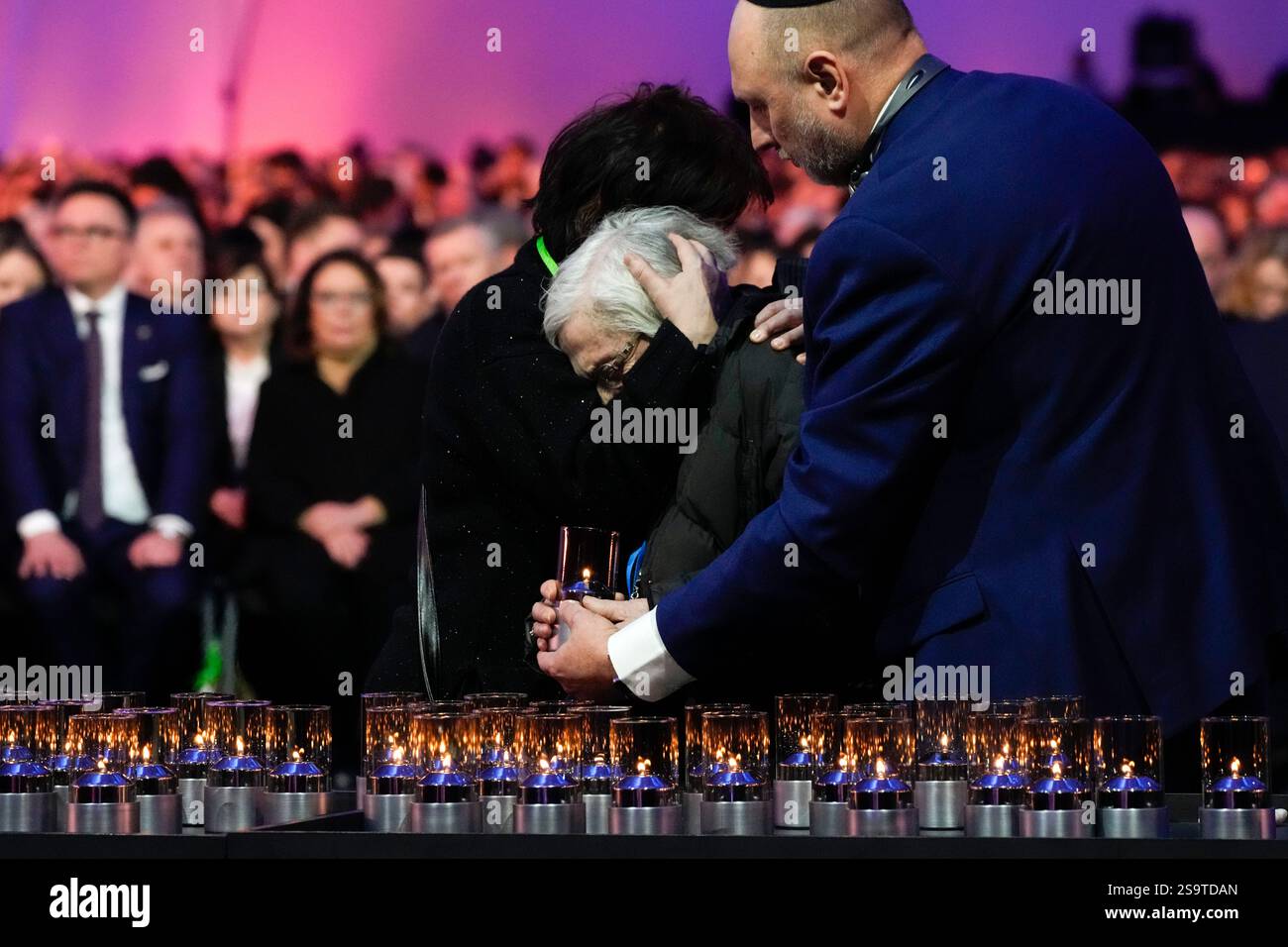 A holocaust survivor gets a hug after placing a lilt candle at the ...