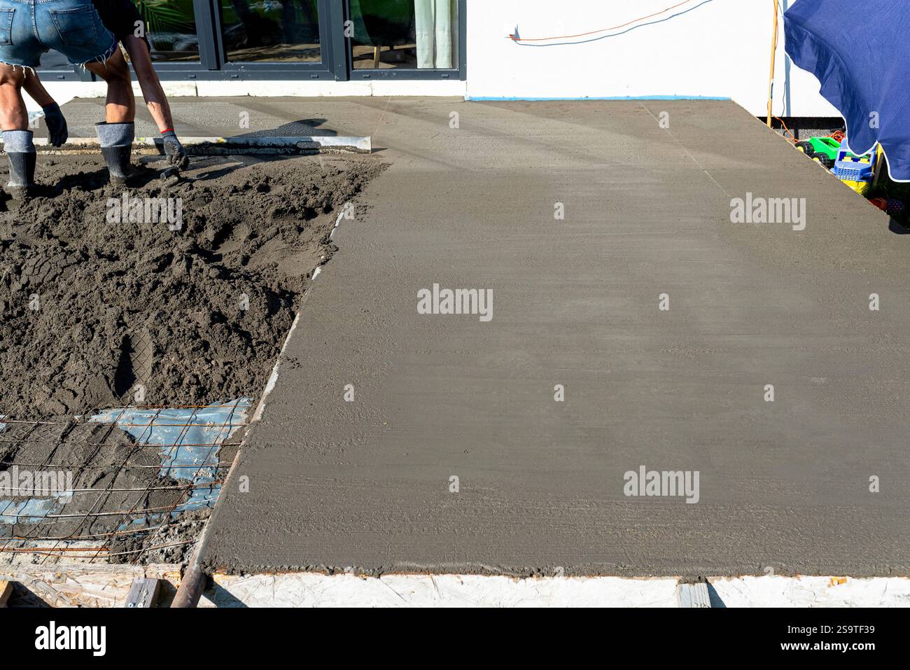Pouring handmade concrete on to a home terrace covered with ...