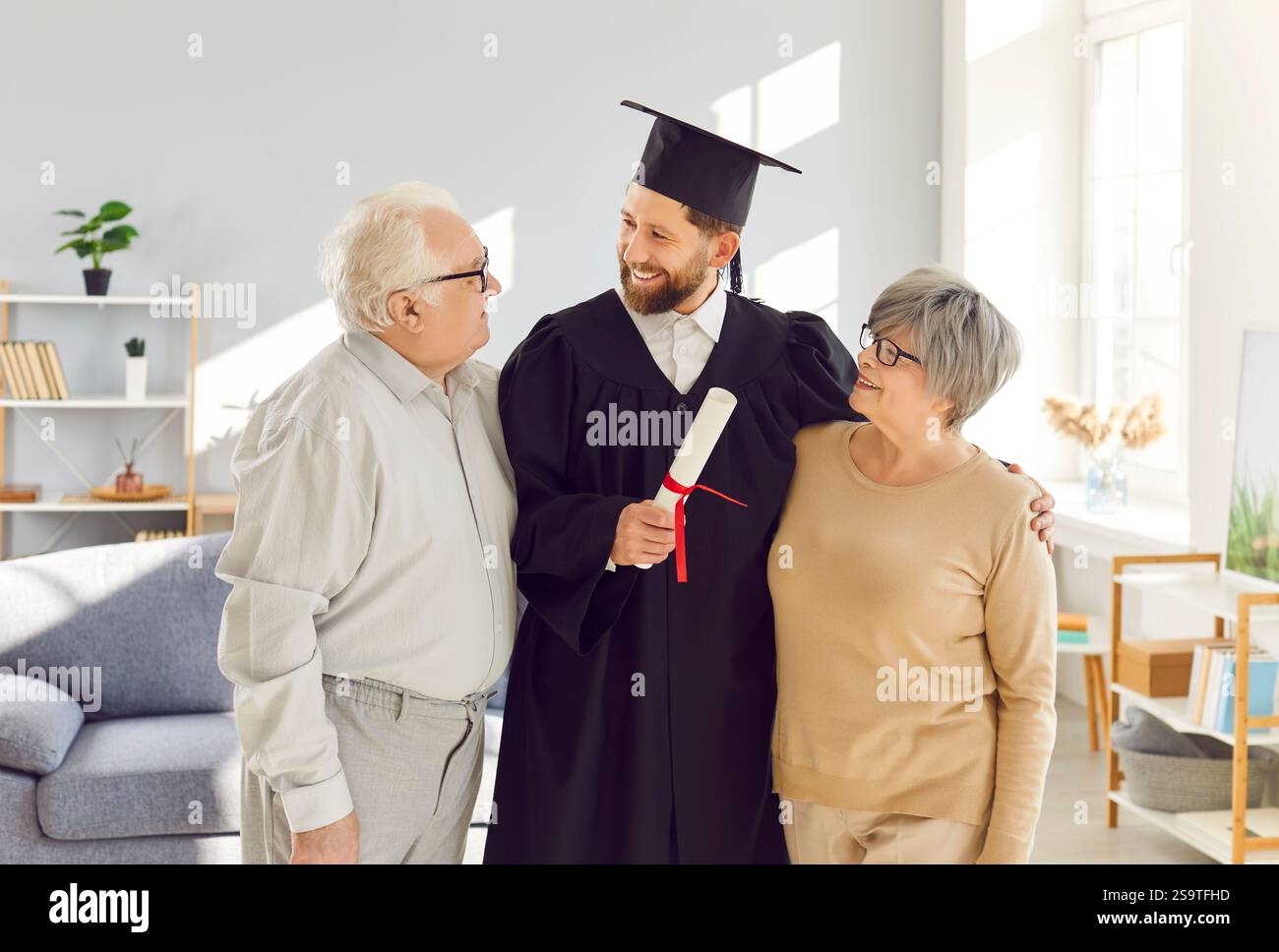 Happy family at home celebrating adult son graduation awarding of ...