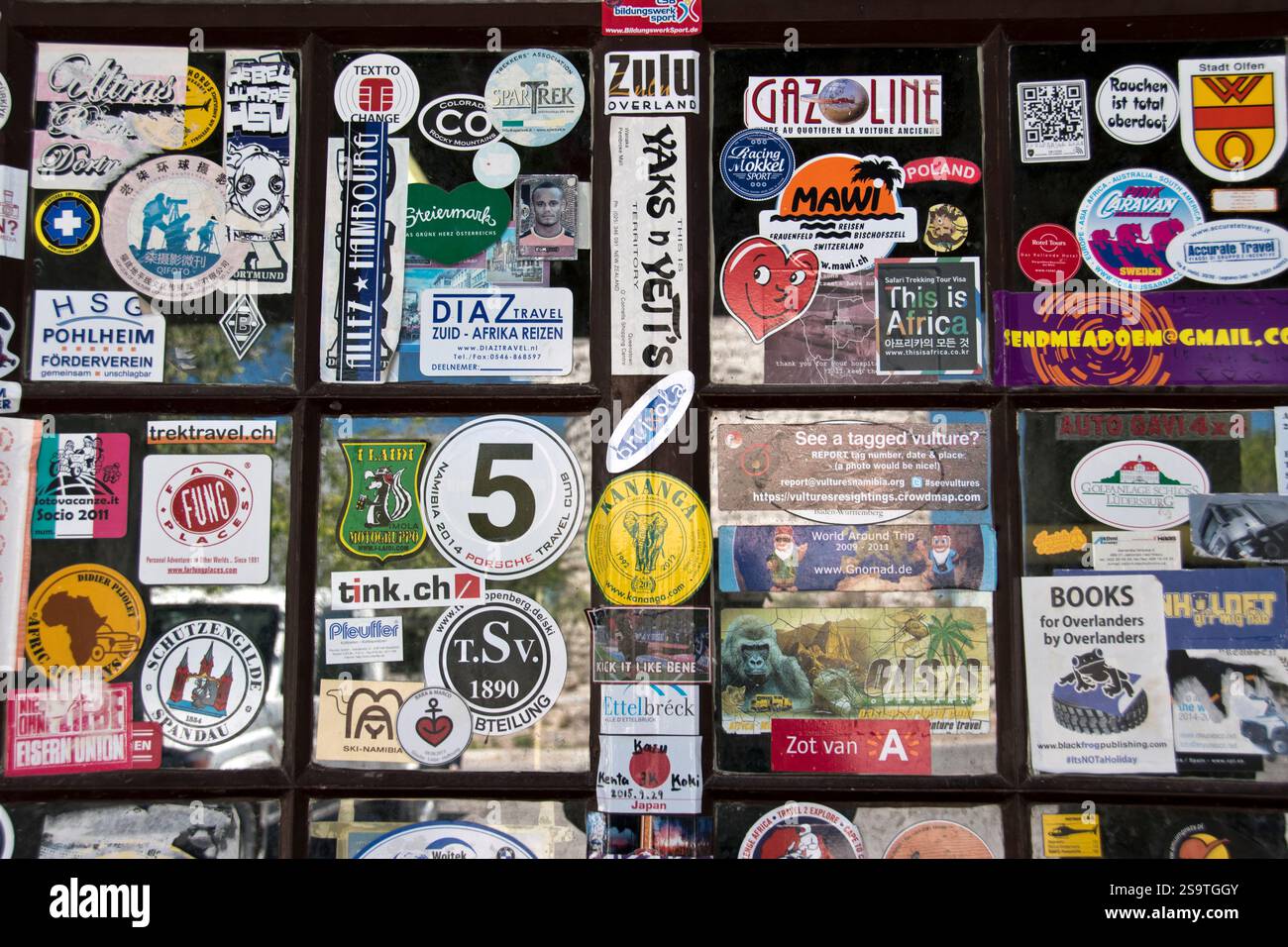 Stickers from around the world cover the window of a shop at the ...