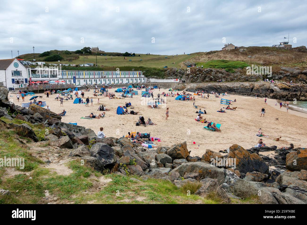 Visitors enjoy a sunny day at Porthgwidden beach in St Ives, Cornwall ...