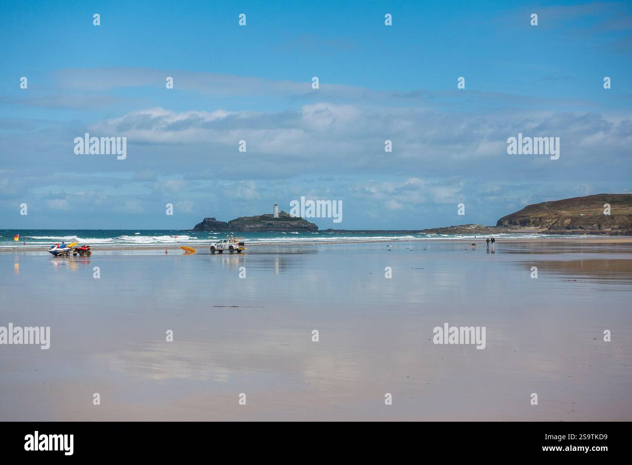 Lifeguard RNLI vehicles are parked on St Gothian Sands with Godrevy ...