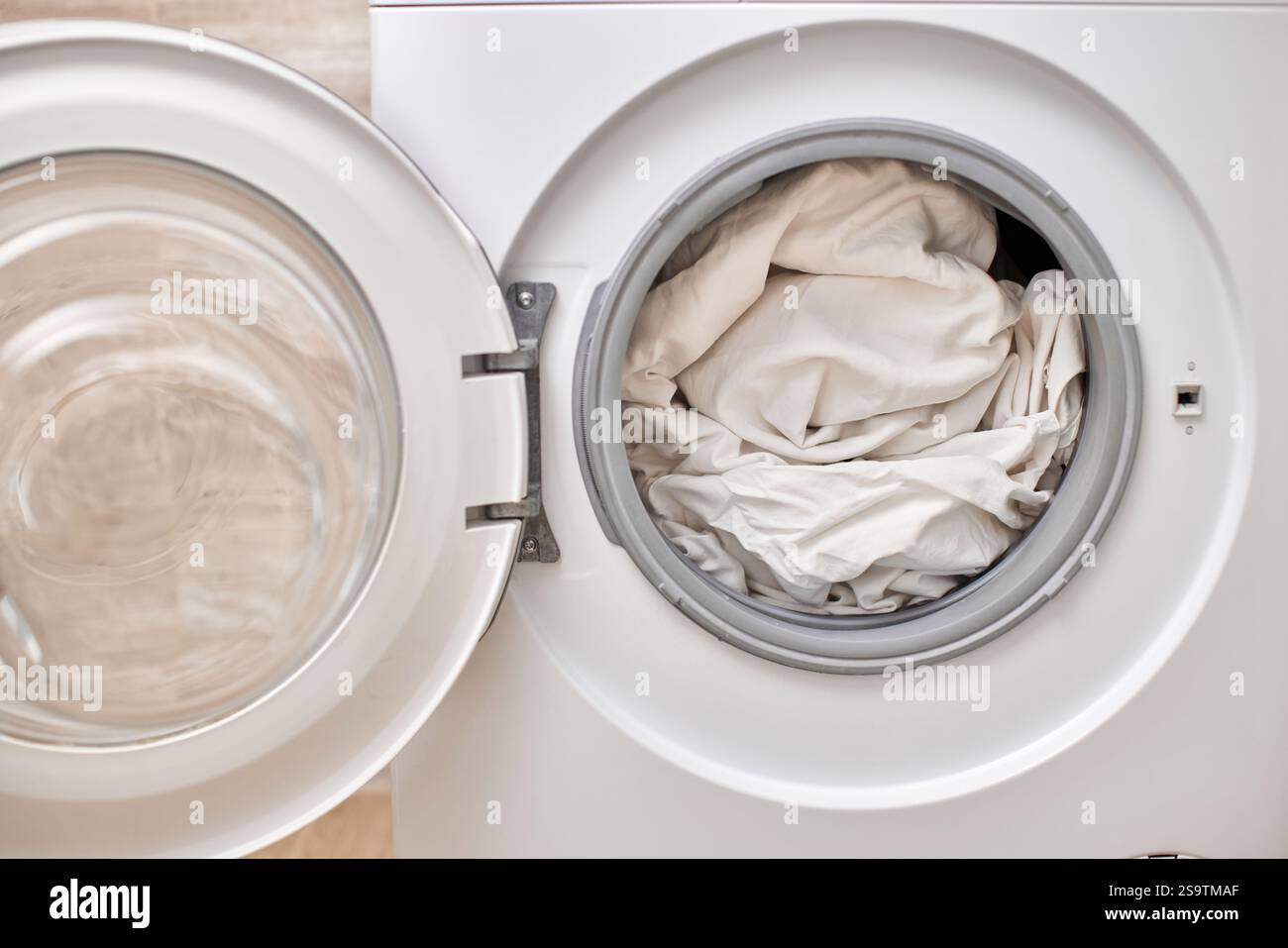 white laundry inside washing machine with open door. Close up Stock ...
