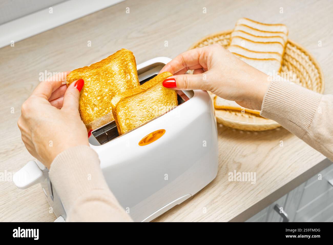 woman hand takes fried toast out of toaster, close-up. woman takes ...