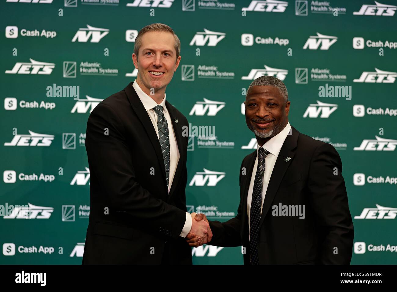 New York Jets new head coach Aaron Glenn, right, and general manager Darren Mougey shake hands ...