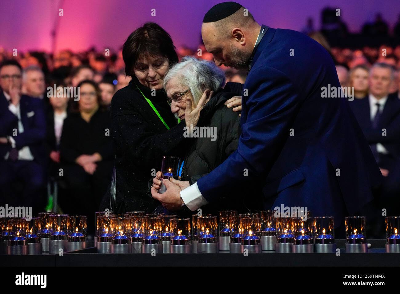 A holocaust survivor gets a hug after placing a lilt candle at the ...