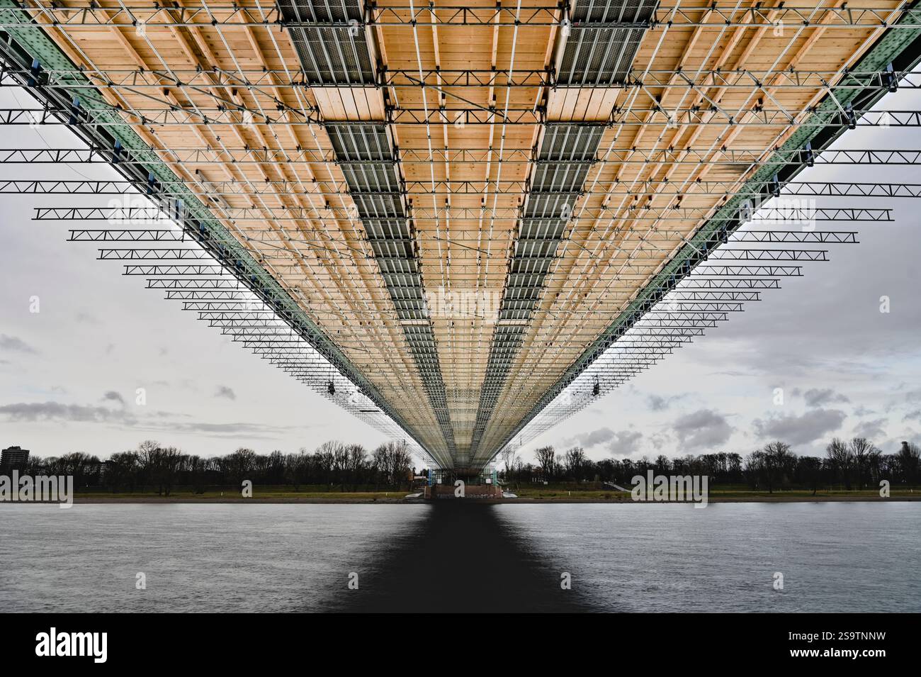 A vast structure spans across the water, showcasing intricate beams and ...