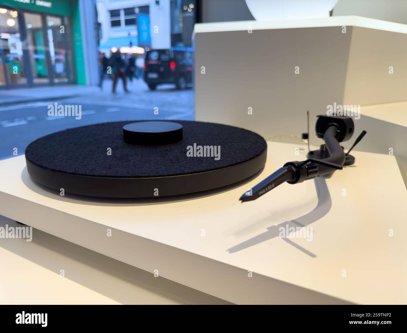 Modern turntable showcased in a vibrant city setting during daylight ...