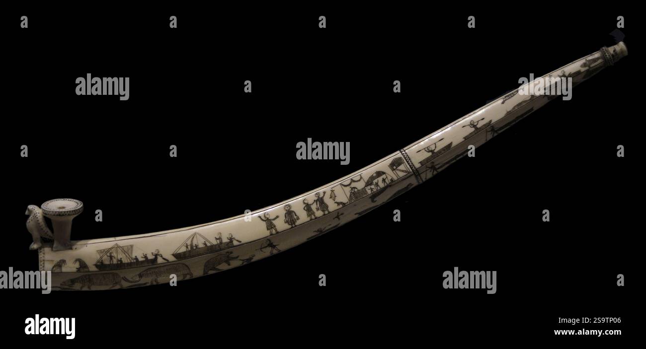Walrus tusk carved as an ornamental pipe featuring hunting scenes with ...