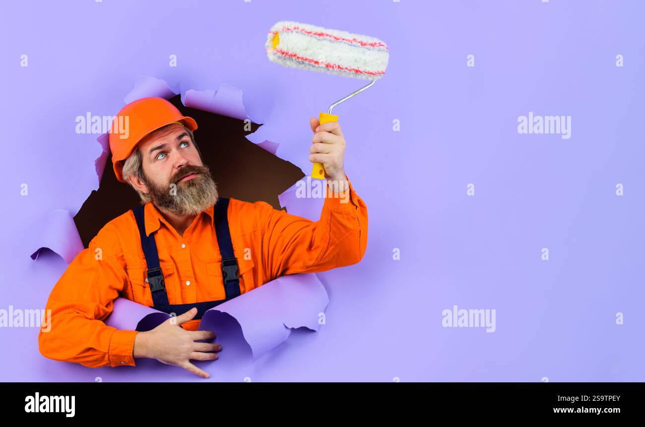 Painter man. Male painter with painting roller looking through paper ...