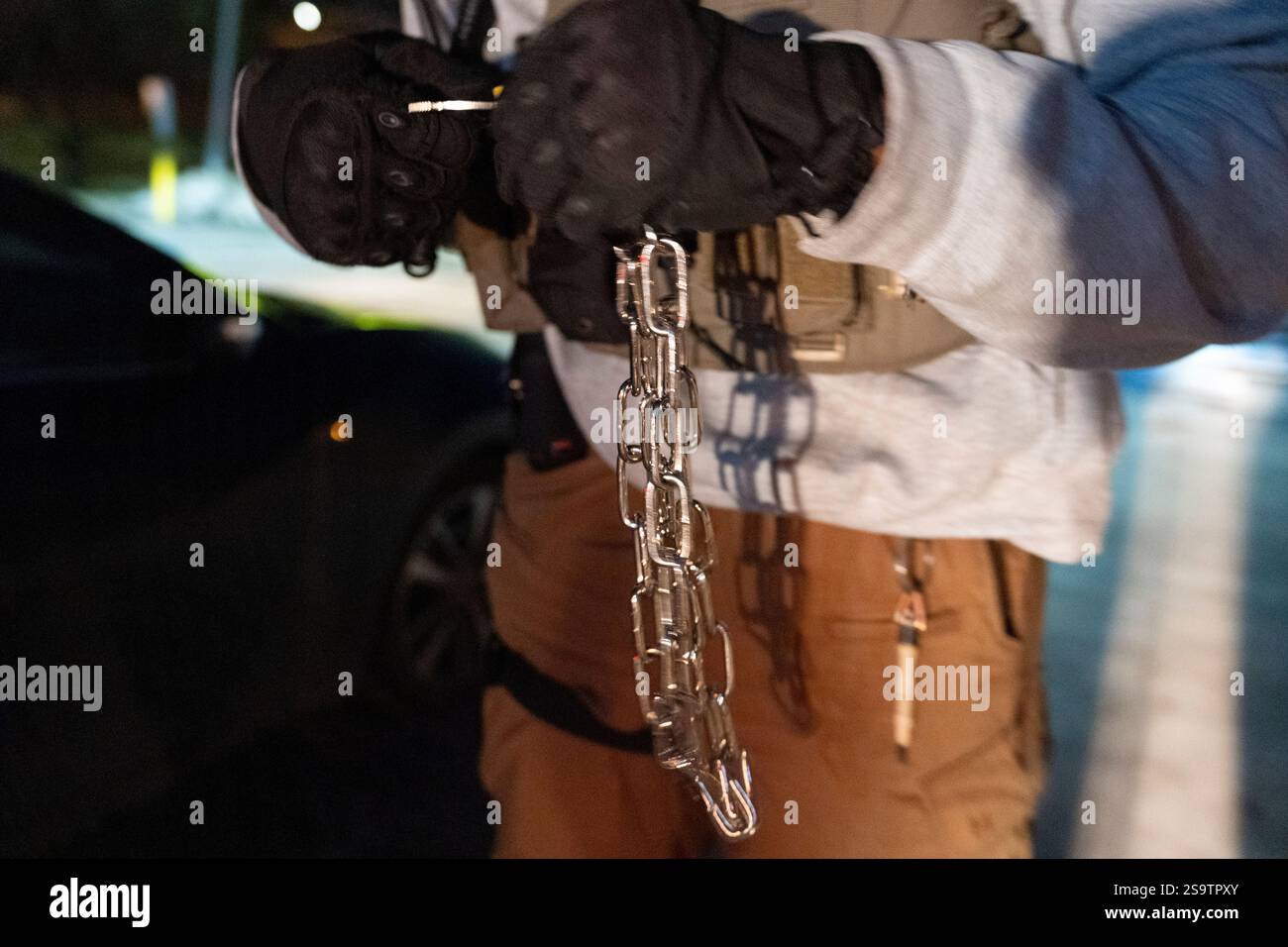 U.S. Immigration and Customs Enforcement officers prepare a chain used ...
