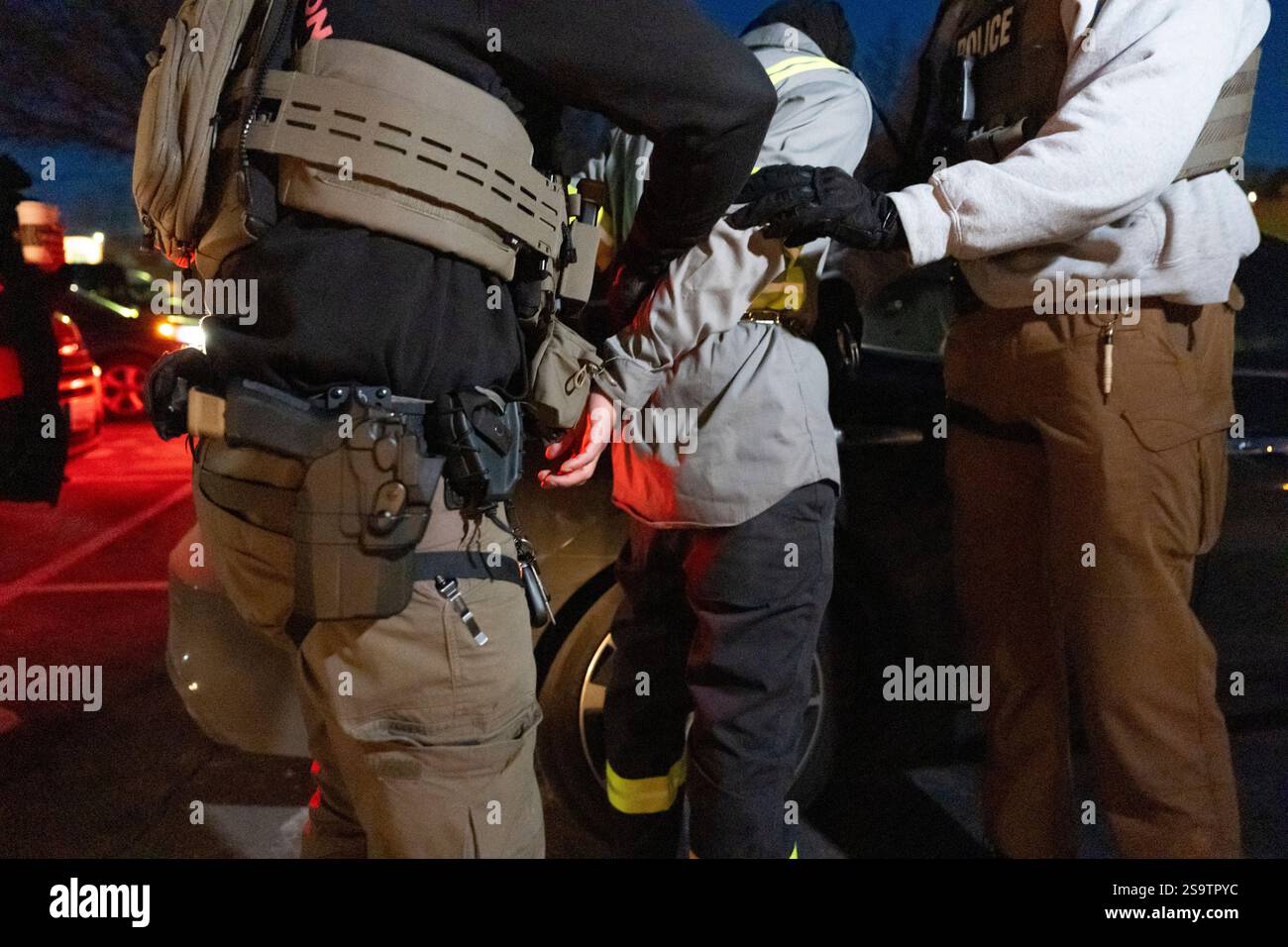 U.S. Immigration and Customs Enforcement officers use a chain to more ...