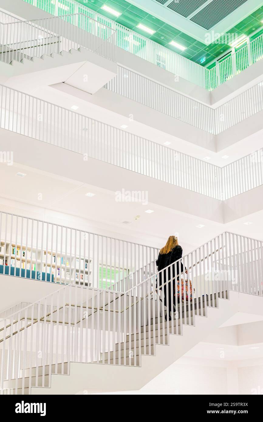 Modern library interior, minimalist staircase, person ascending ...