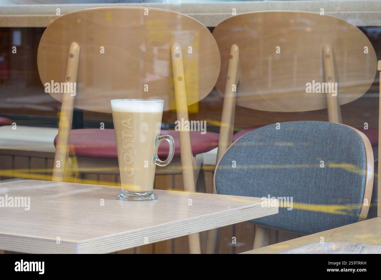 Looking in through a Costa cafe to a coffee cup on a table, Glasgow ...