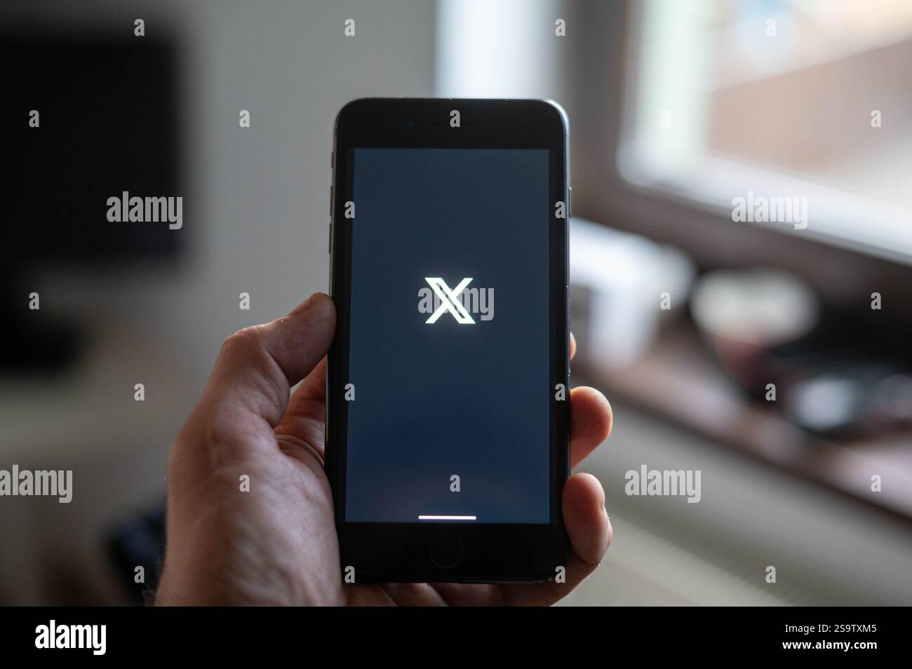 A man using X new twitter application on her smartphones Stock Photo ...