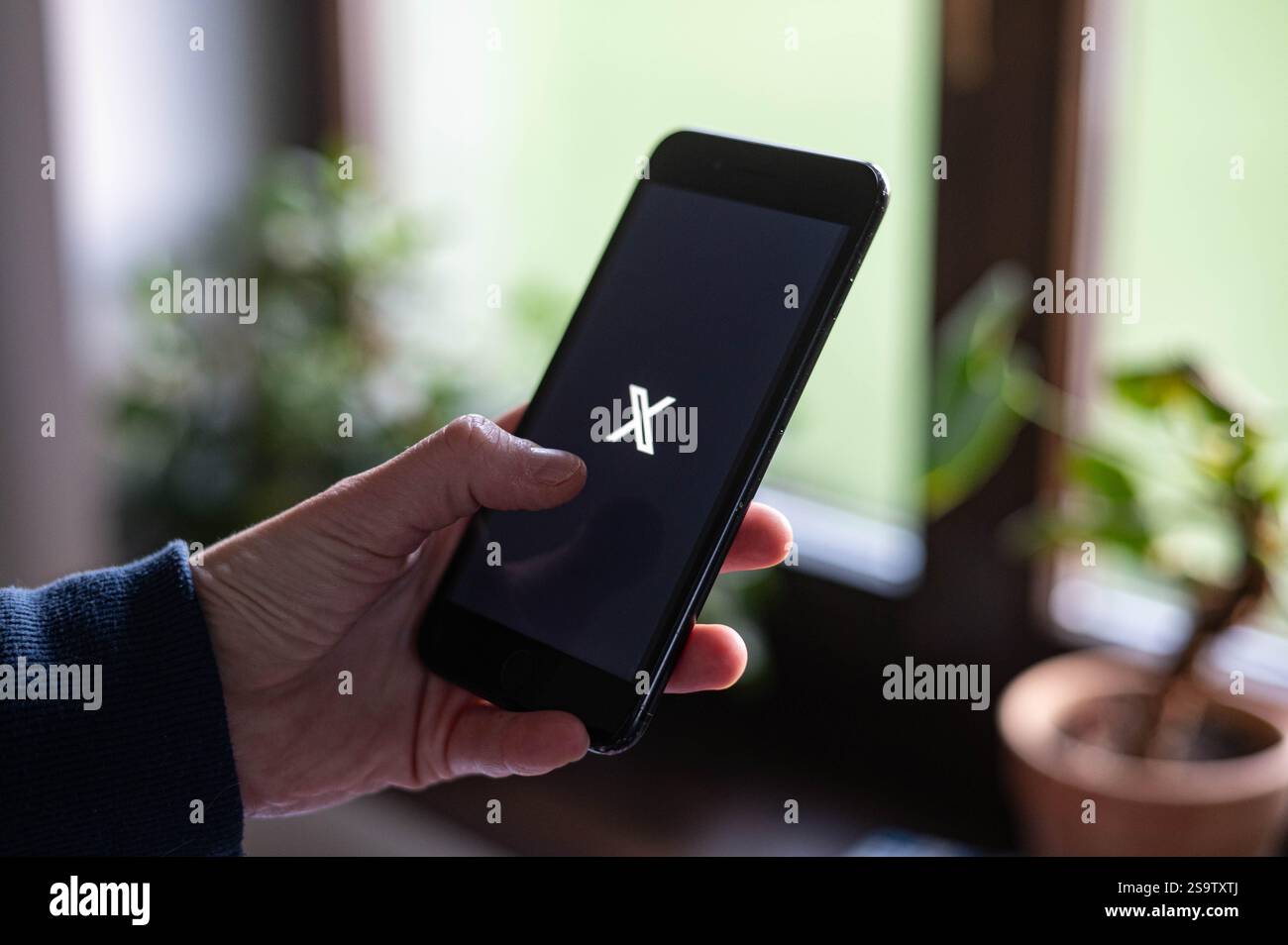 A man using X new twitter application on her smartphones Stock Photo ...