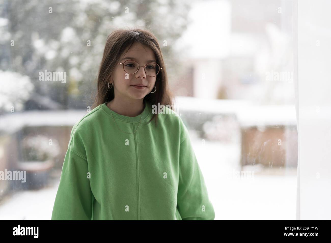 Little cute german girl with glasses and long hair stands in front of a ...