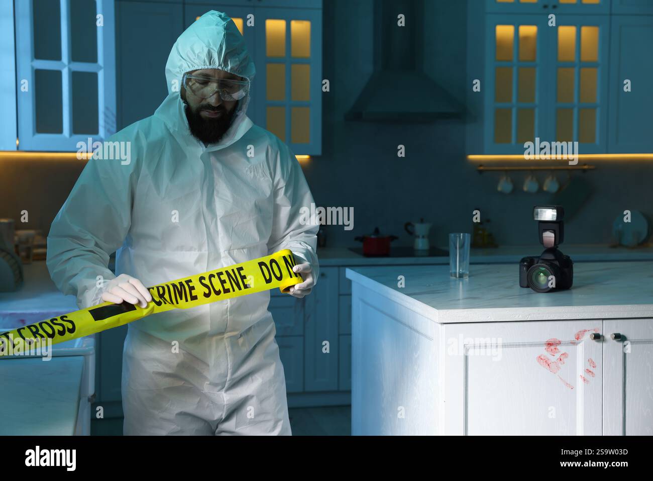 Forensic expert blocking way to crime scene with yellow tape indoors ...