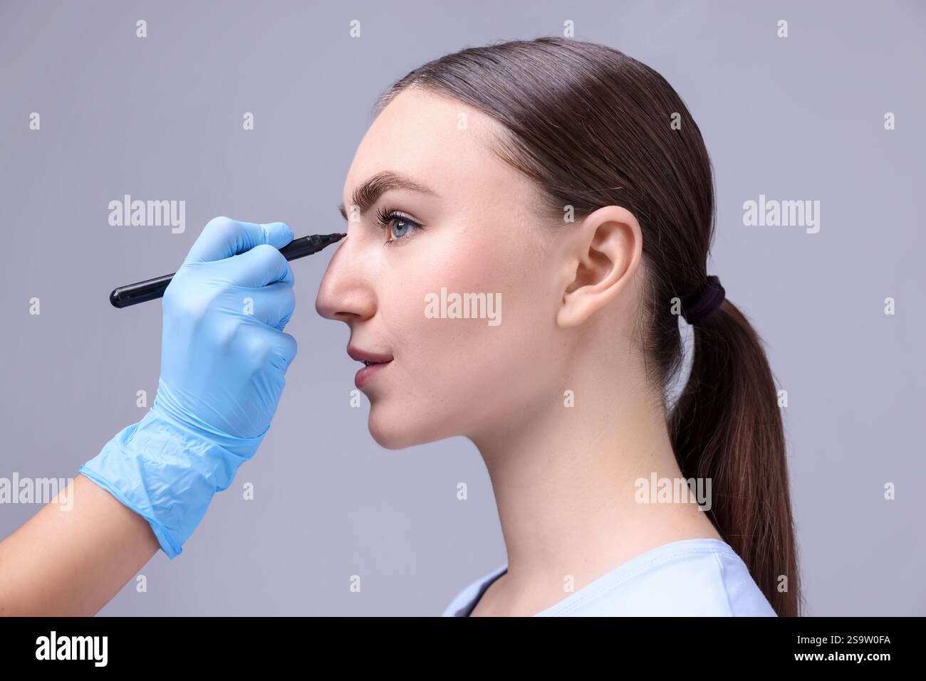 Doctor drawing marks on patient's nose for plastic surgery operation ...